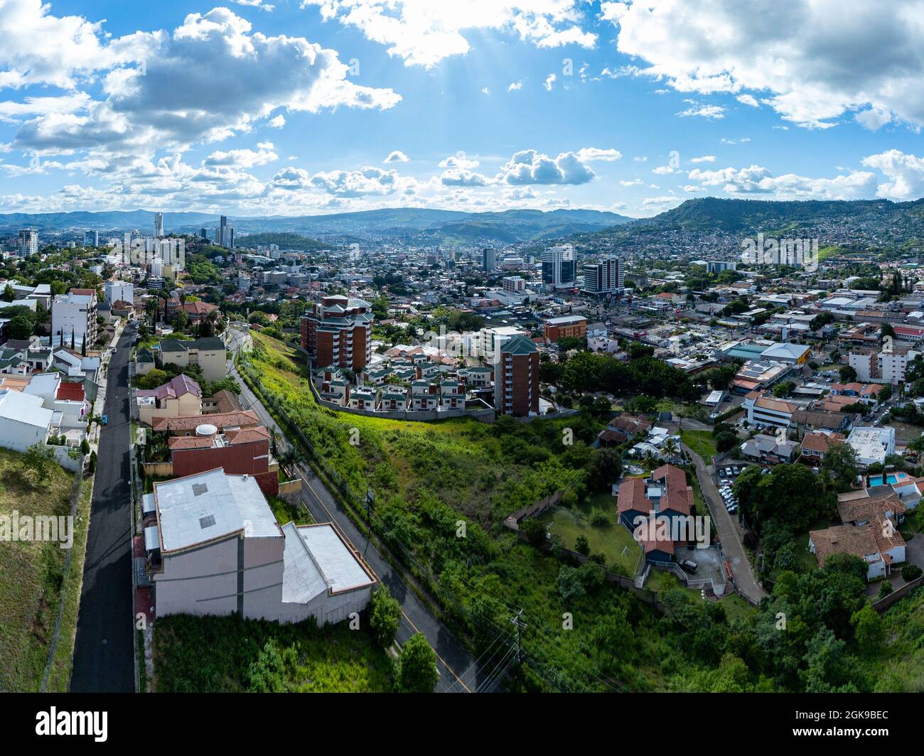 Aerial view of a beautiful town with hills and mountains under the blue ...