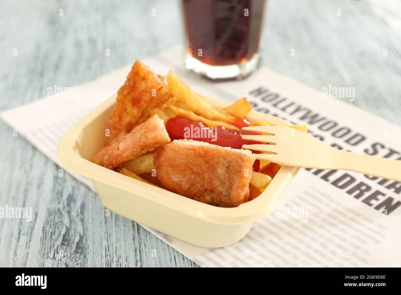 Tasty fried fish and chips in packaging on wooden background Stock ...