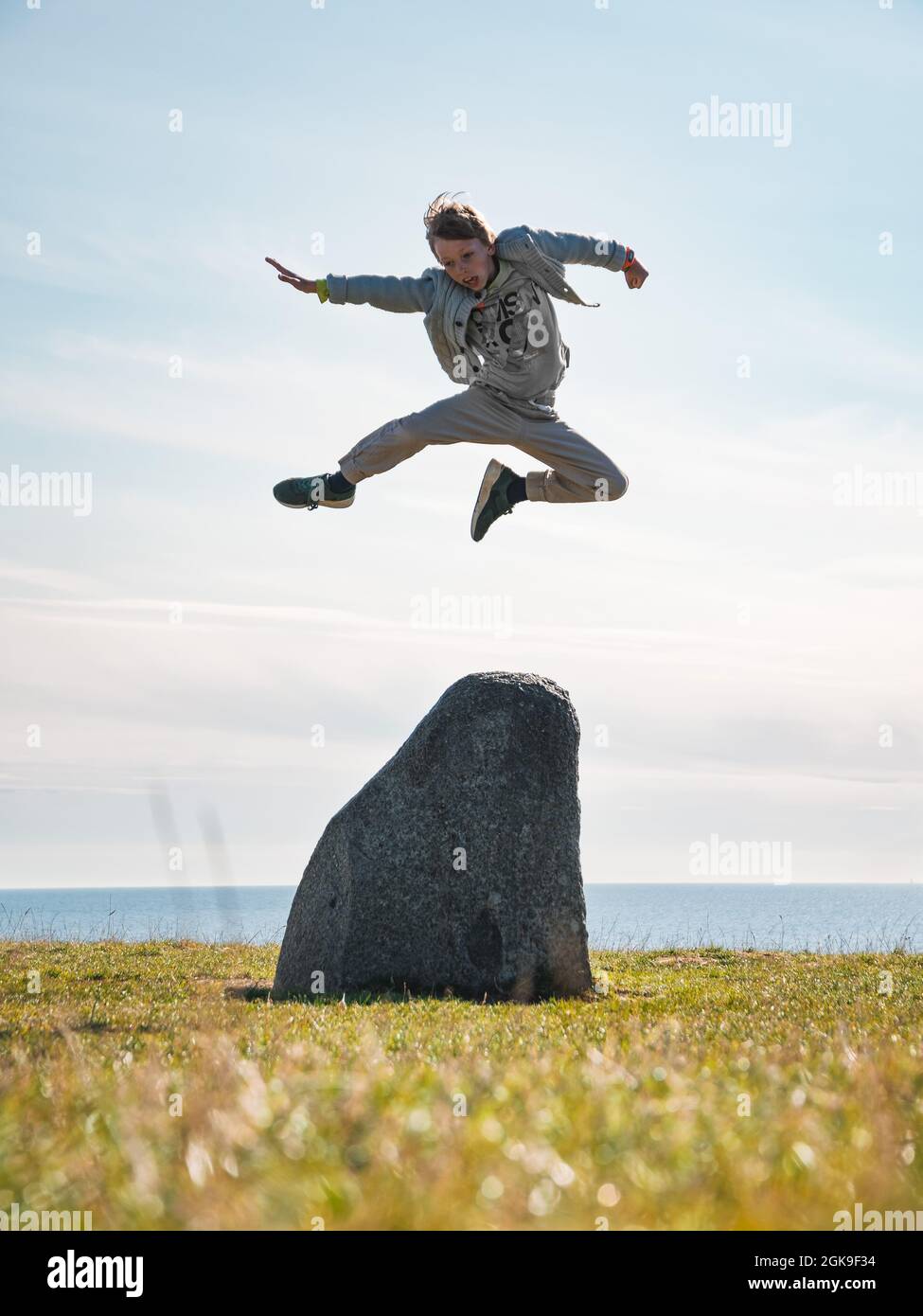 Boy jumping off rocks hi-res stock photography and images - Alamy
