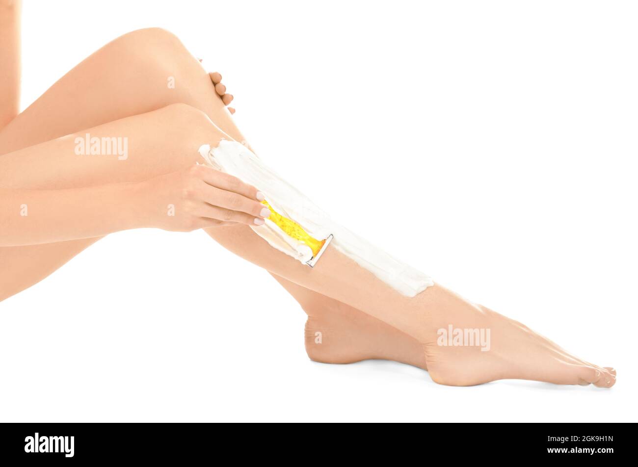 Young woman shaving leg on white background Stock Photo - Alamy