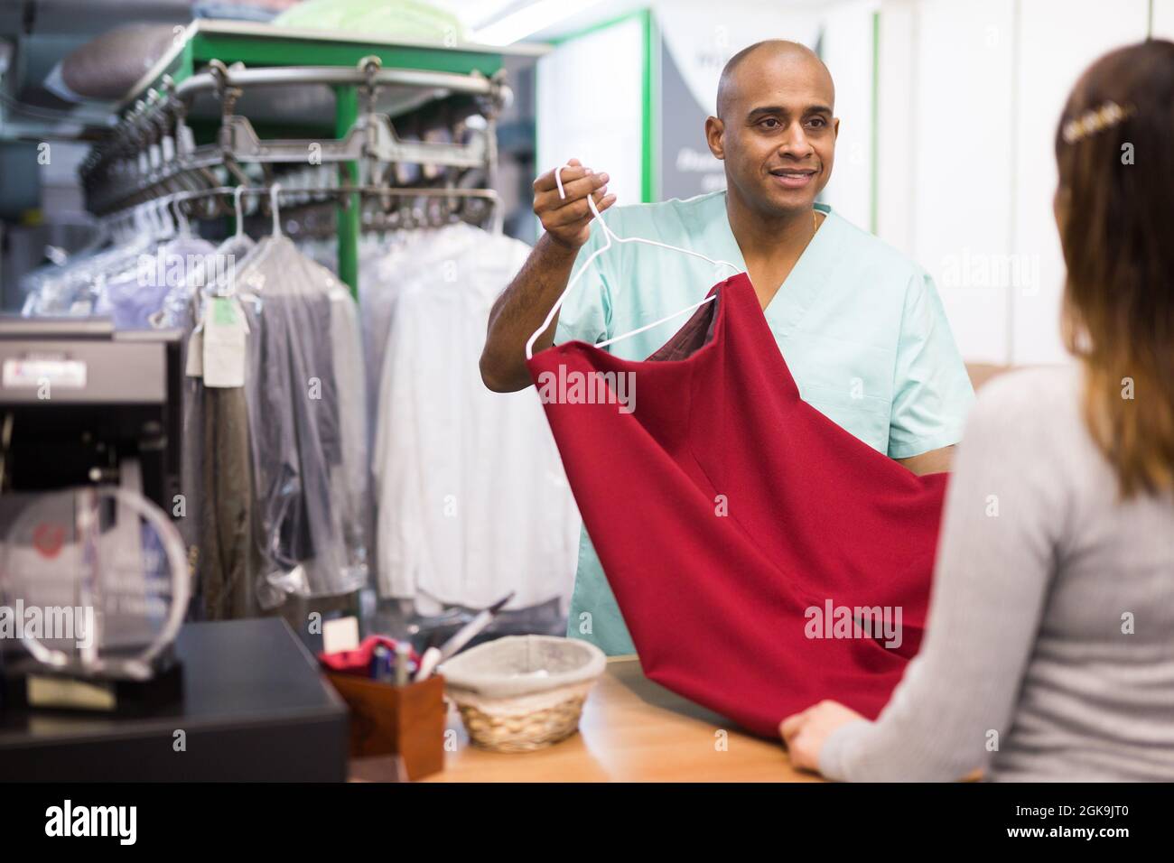 Man dry-cleaning worker giving clothes to customer Stock Photo - Alamy