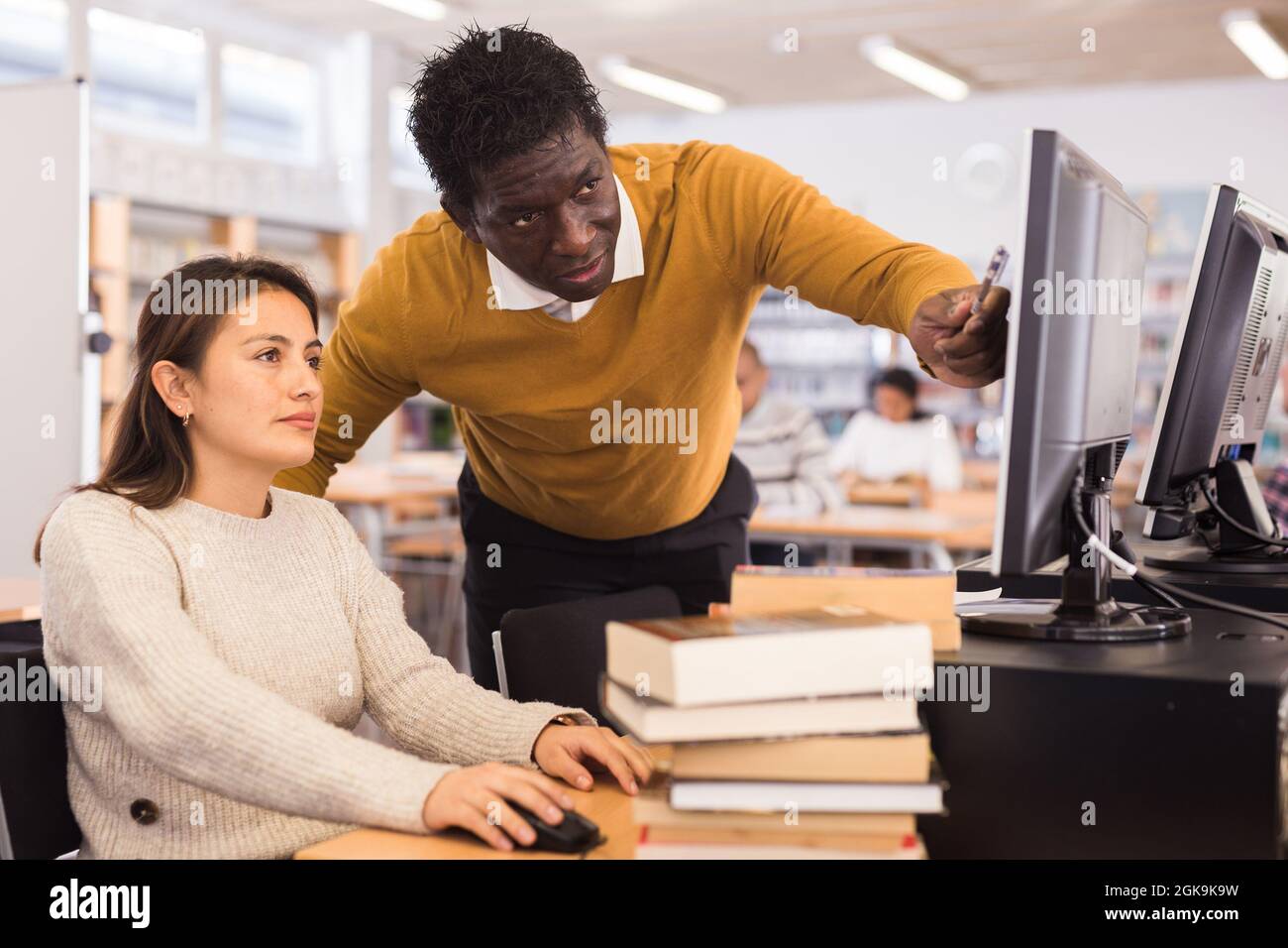 Portrait of librarian assisting woman in library Stock Photo - Alamy