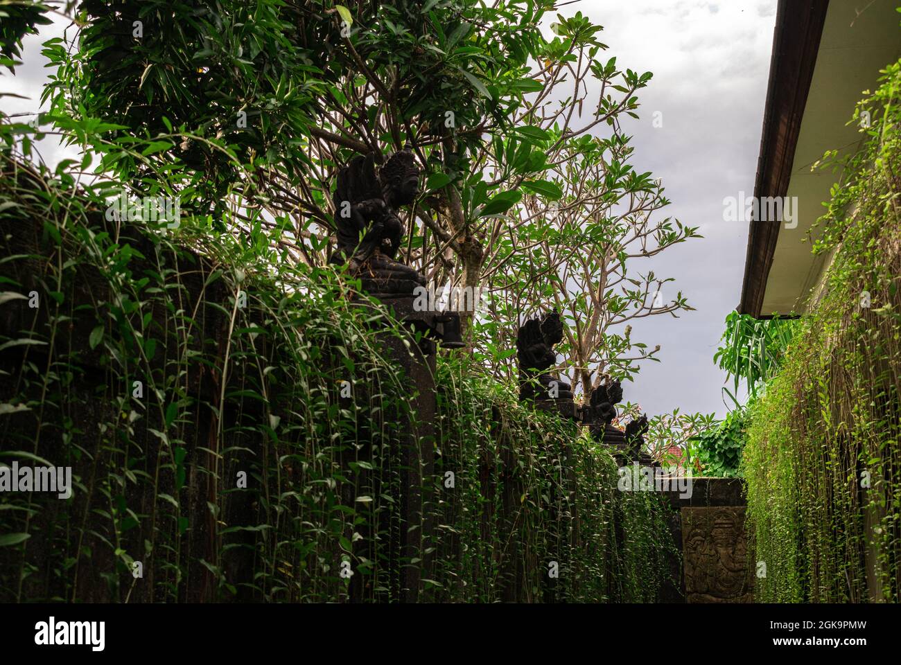 garden with balinese angel statues on the wall Stock Photo - Alamy