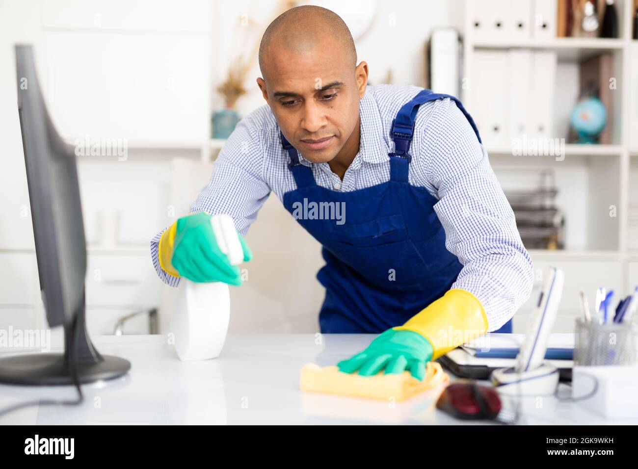 Latin cleaner at work in office near computer desk Stock Photo - Alamy