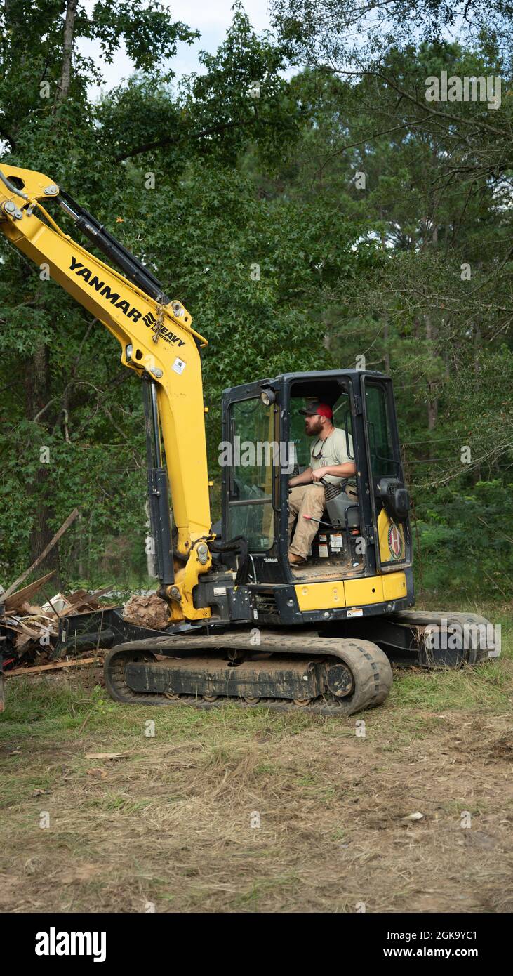 yellow yanmar backhoe demolishing old brick chimney to clear a lot ...