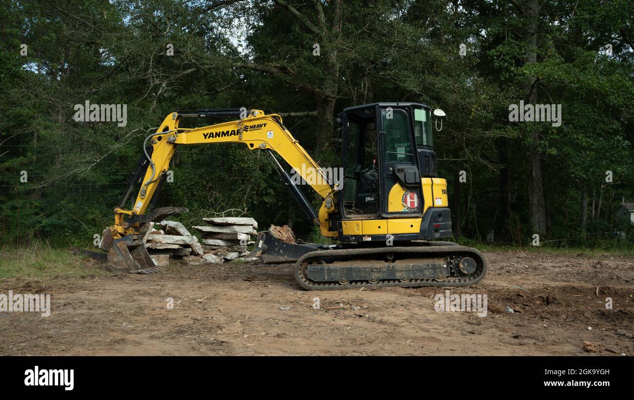 yellow yanmar backhoe demolishing old brick chimney to clear a lot ...