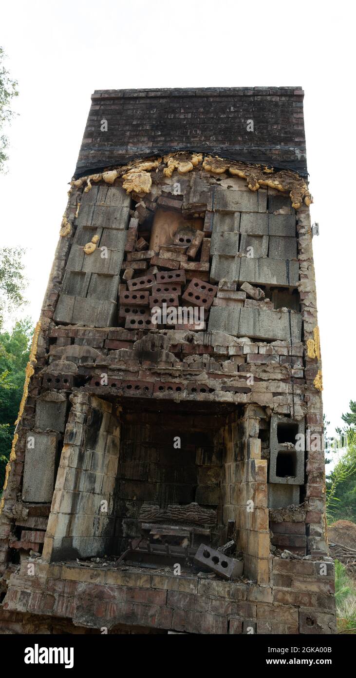 yellow yanmar backhoe demolishing old brick chimney to clear a lot ...