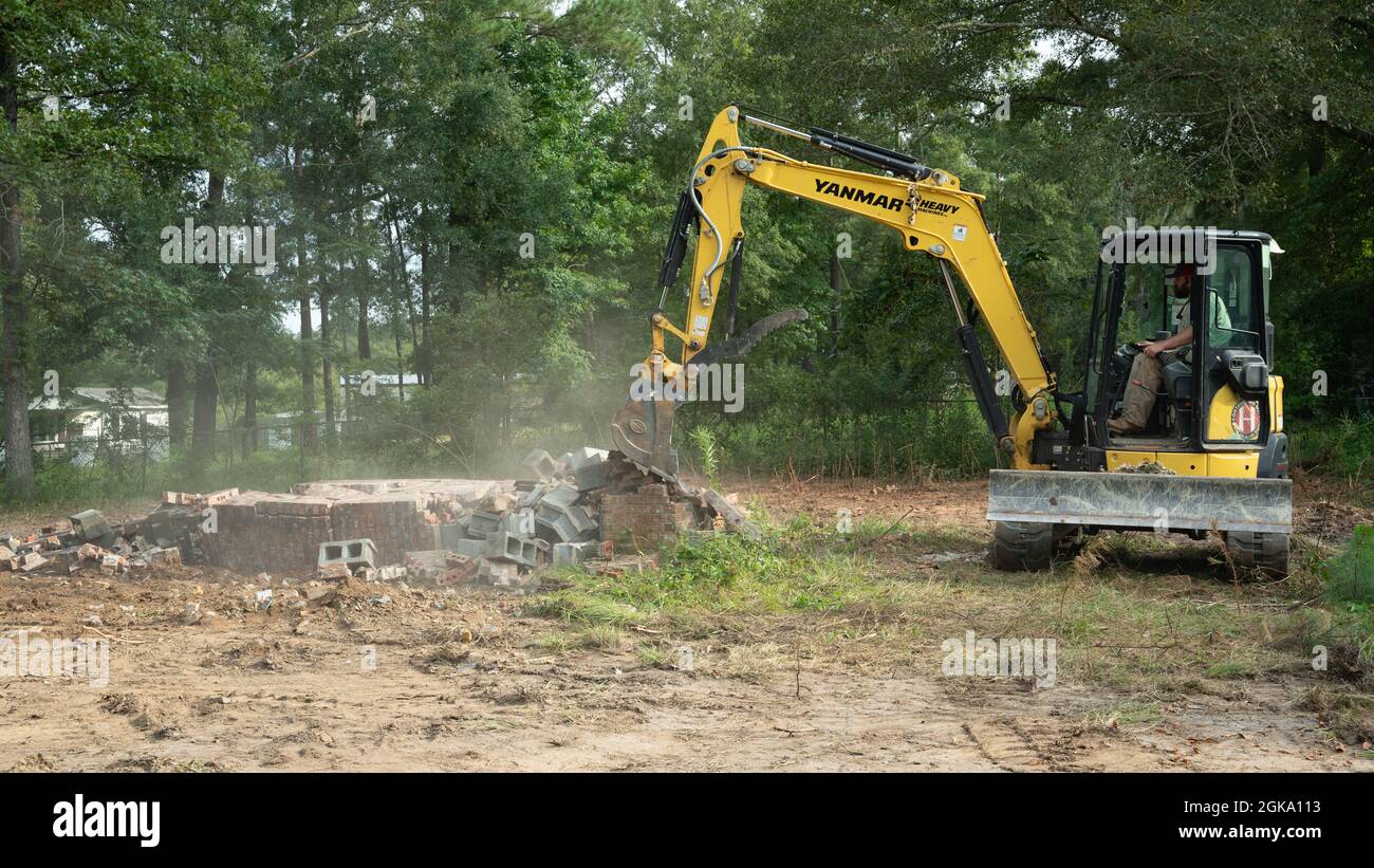 yellow yanmar backhoe demolishing old brick chimney to clear a lot ...