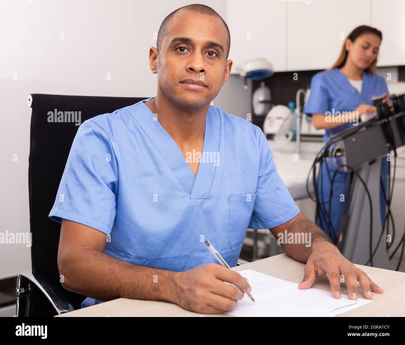 Male cosmetologist working with documents in aesthetic medicine office ...
