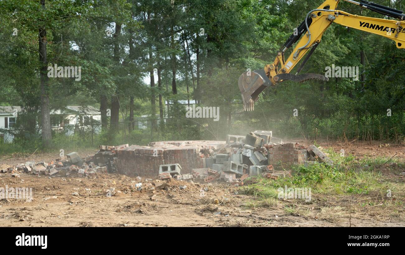 yellow yanmar backhoe demolishing old brick chimney to clear a lot ...