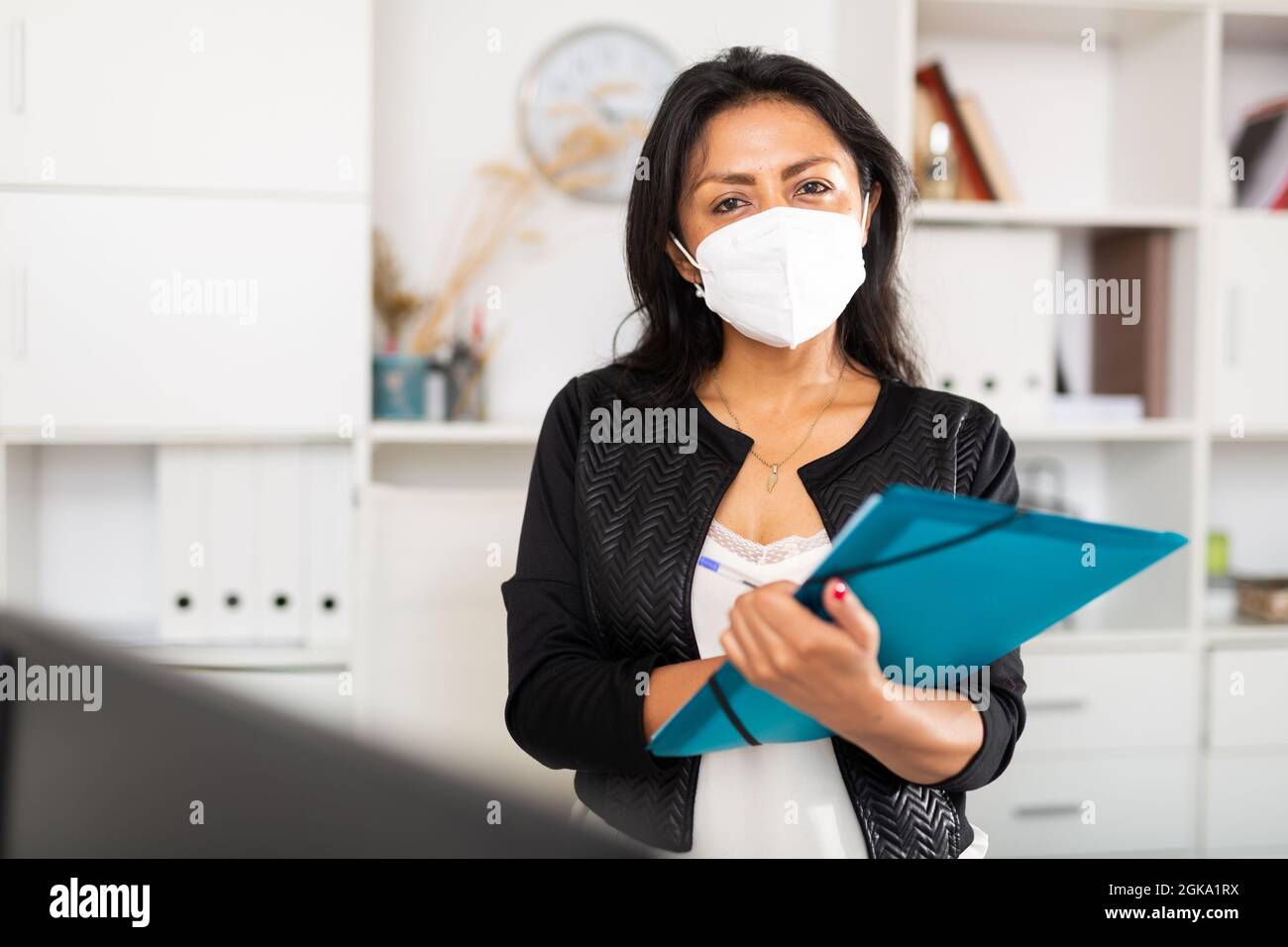Female business assistant in face mask noting tasks Stock Photo - Alamy