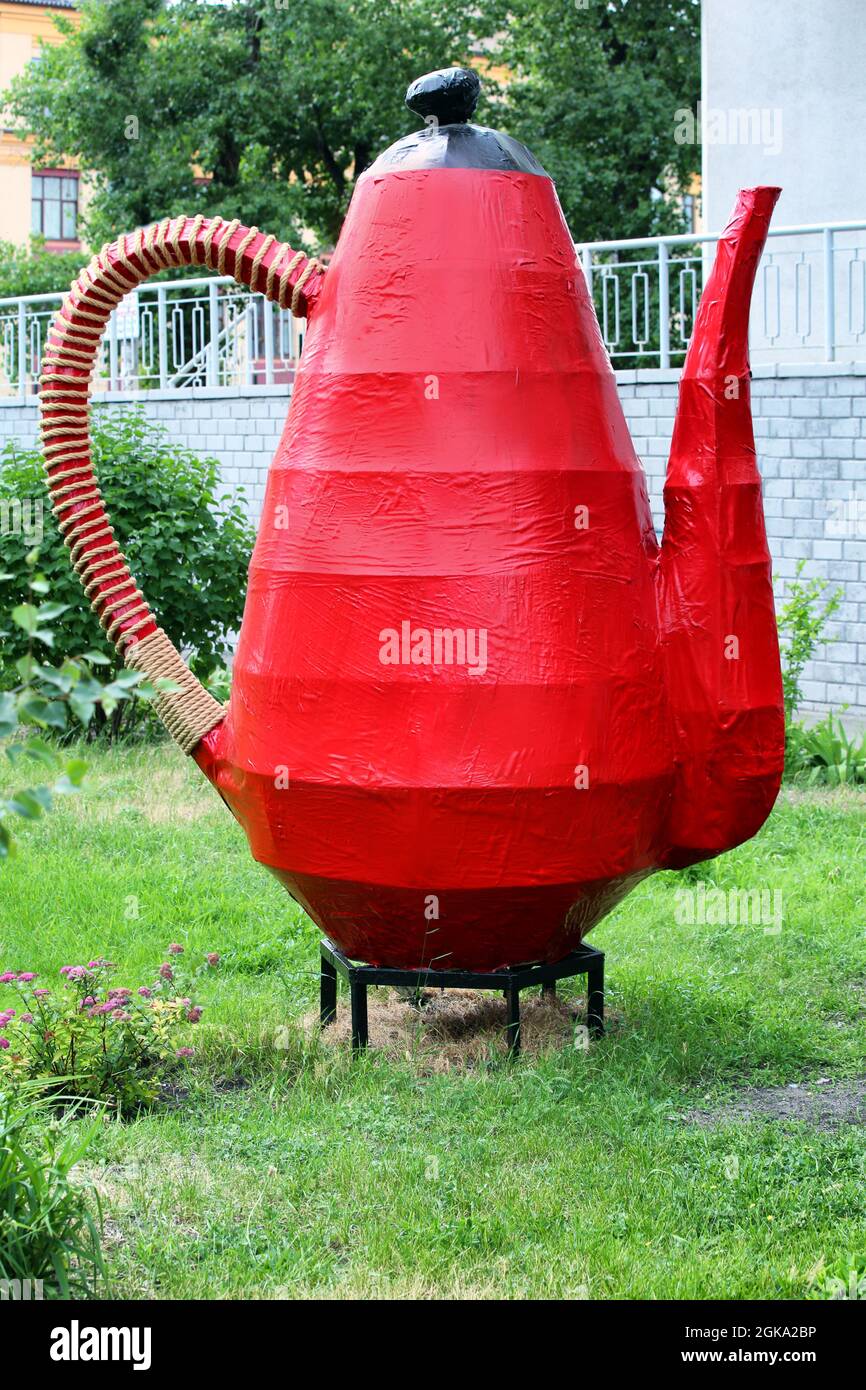 Big red teapot made from old garbage, outdoors Stock Photo - Alamy