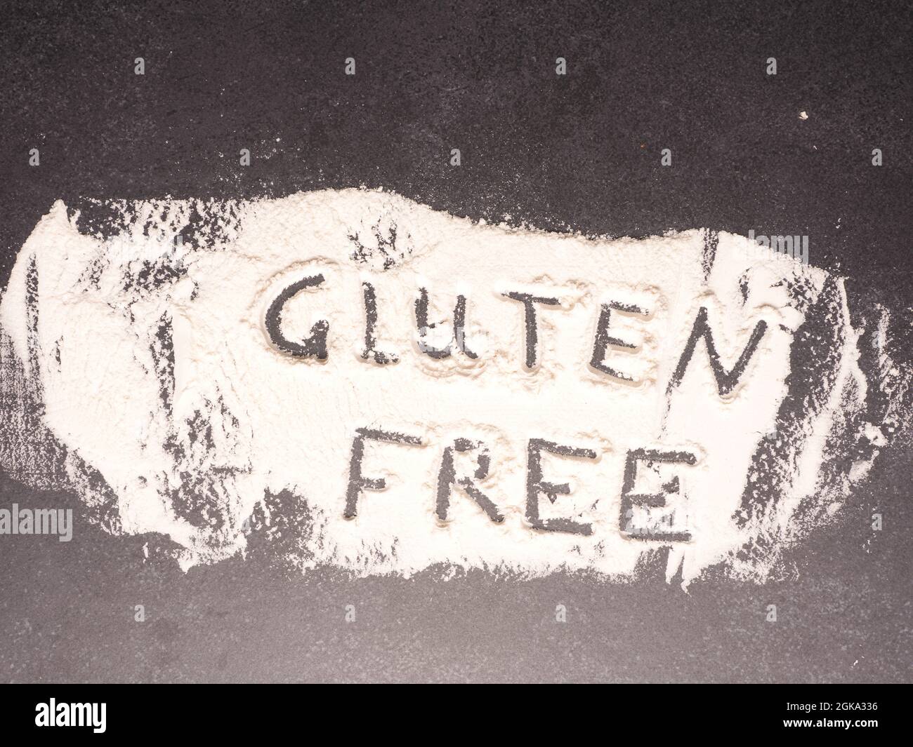 Gluten free written in flour on a dark stone kitchen table, healthy ...