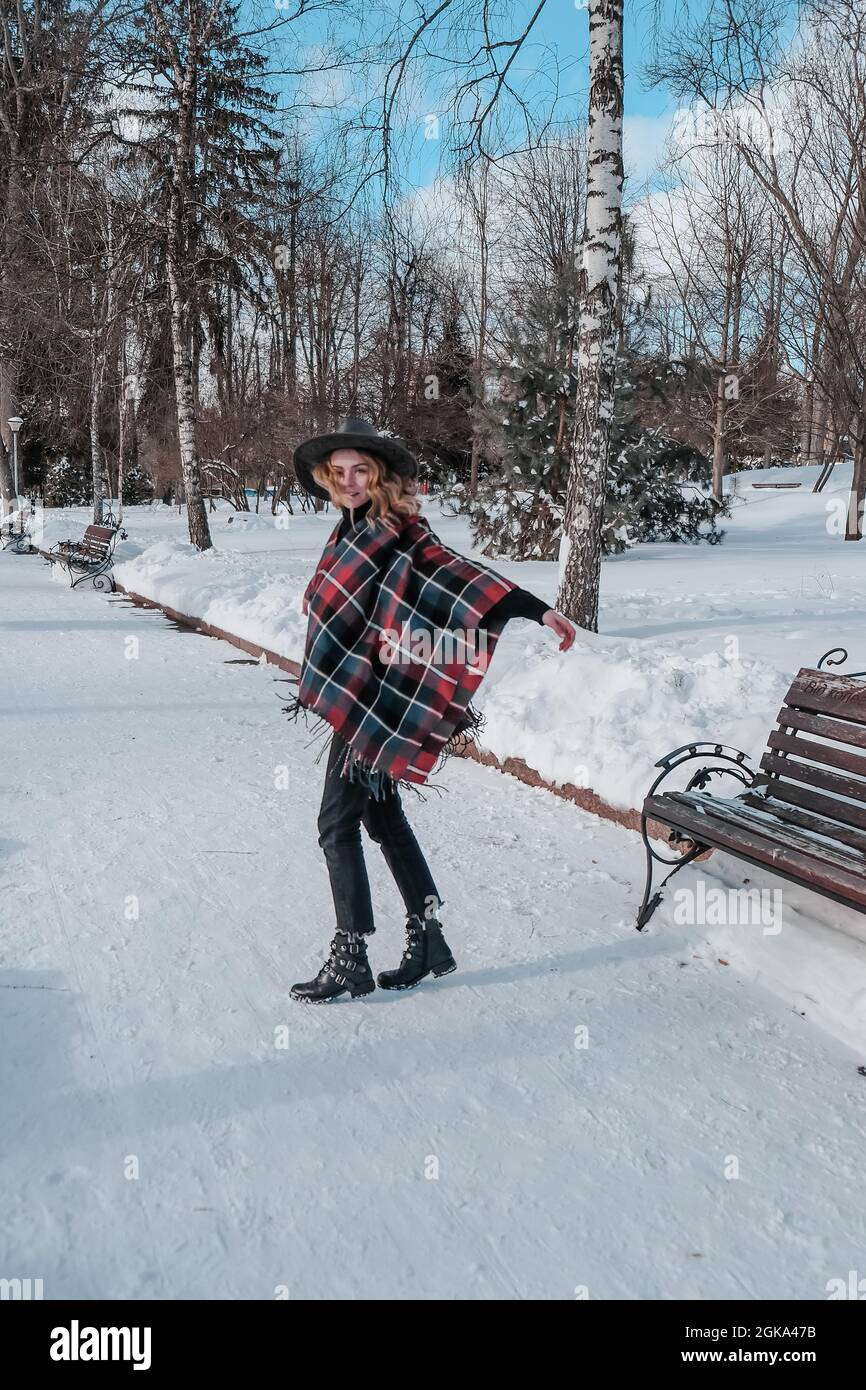 Young woman enjoying winter weather in the snow park. Cold weather ...
