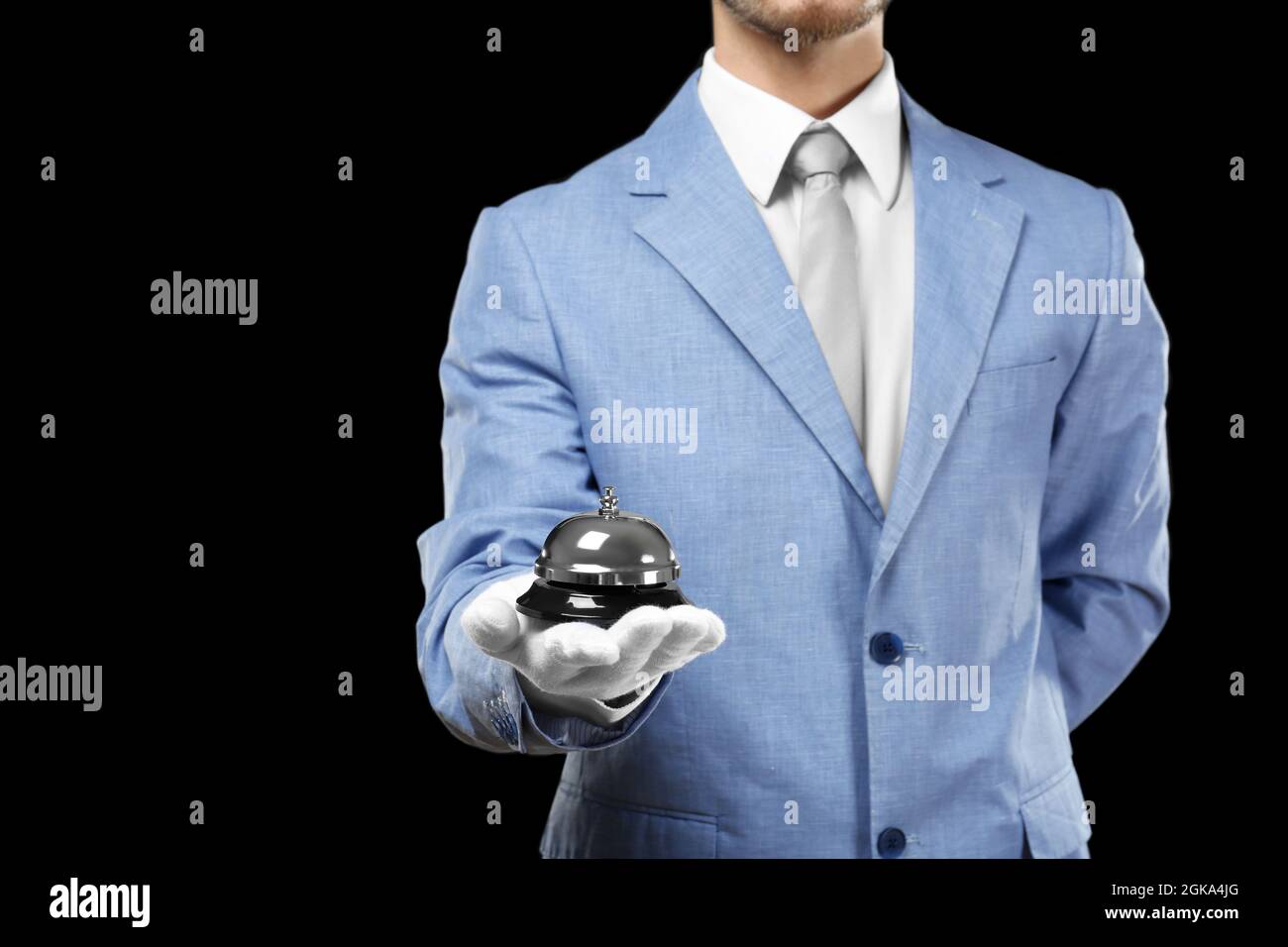 Man holding bell on black background Stock Photo - Alamy