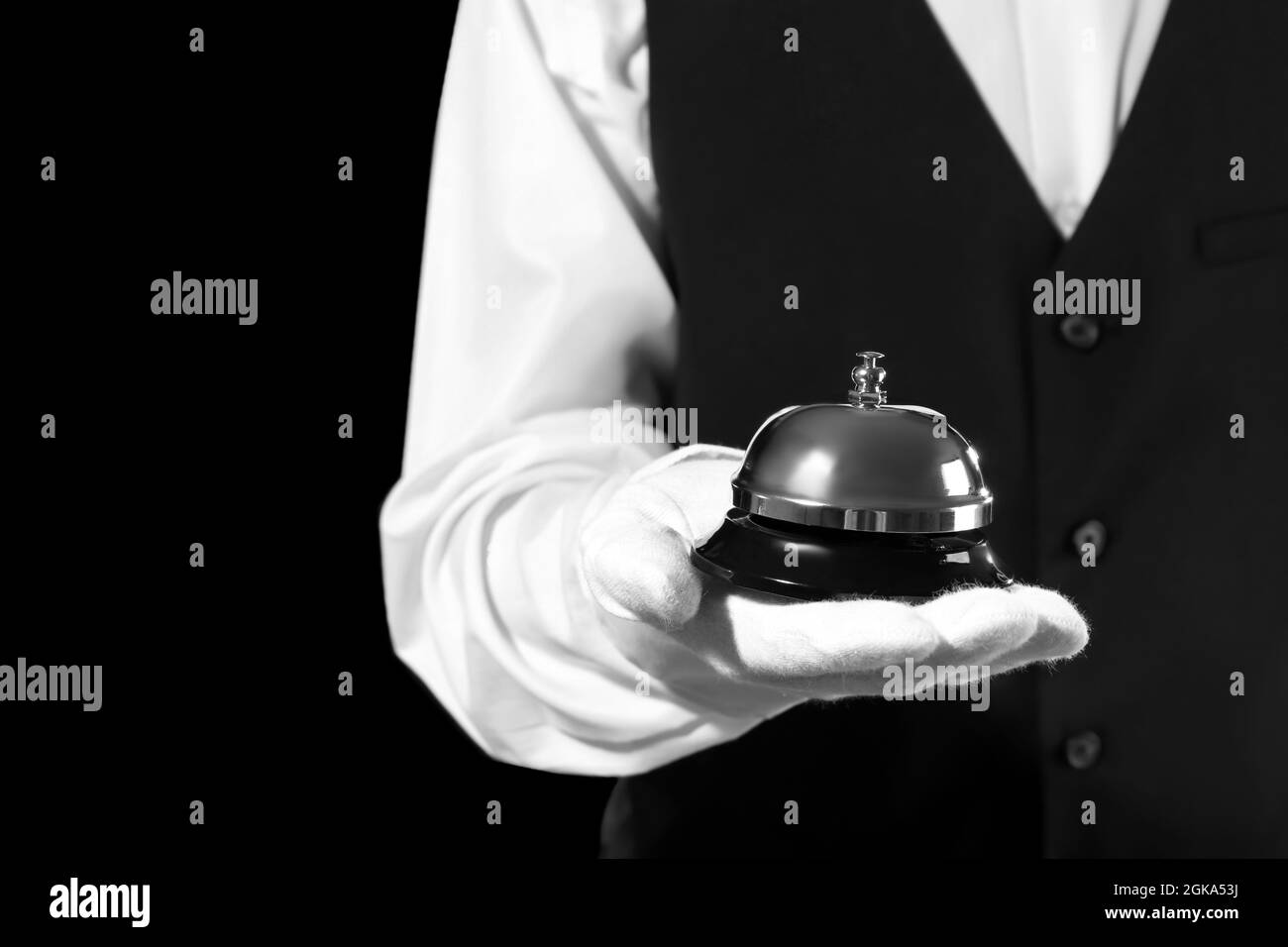 Man holding bell on black background Stock Photo - Alamy