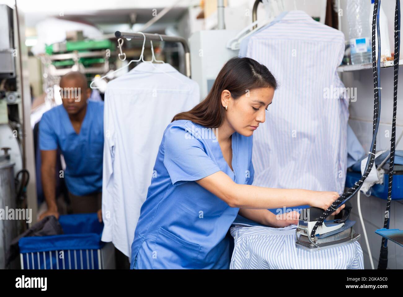 Woman laundry worker ironing shirt at dry-cleaning Stock Photo - Alamy