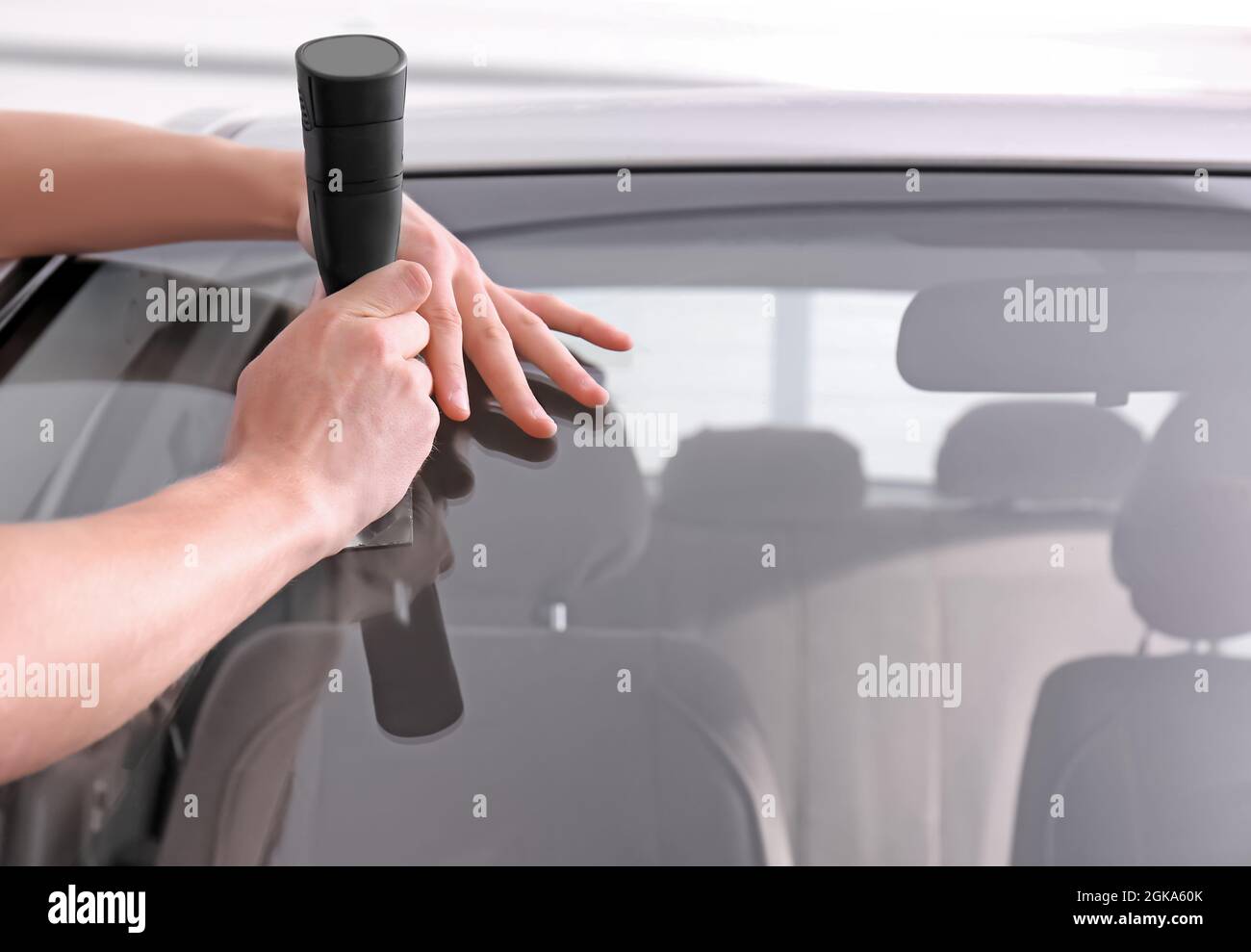 Specialist fixing crack on car windshield in repair shop Stock Photo ...