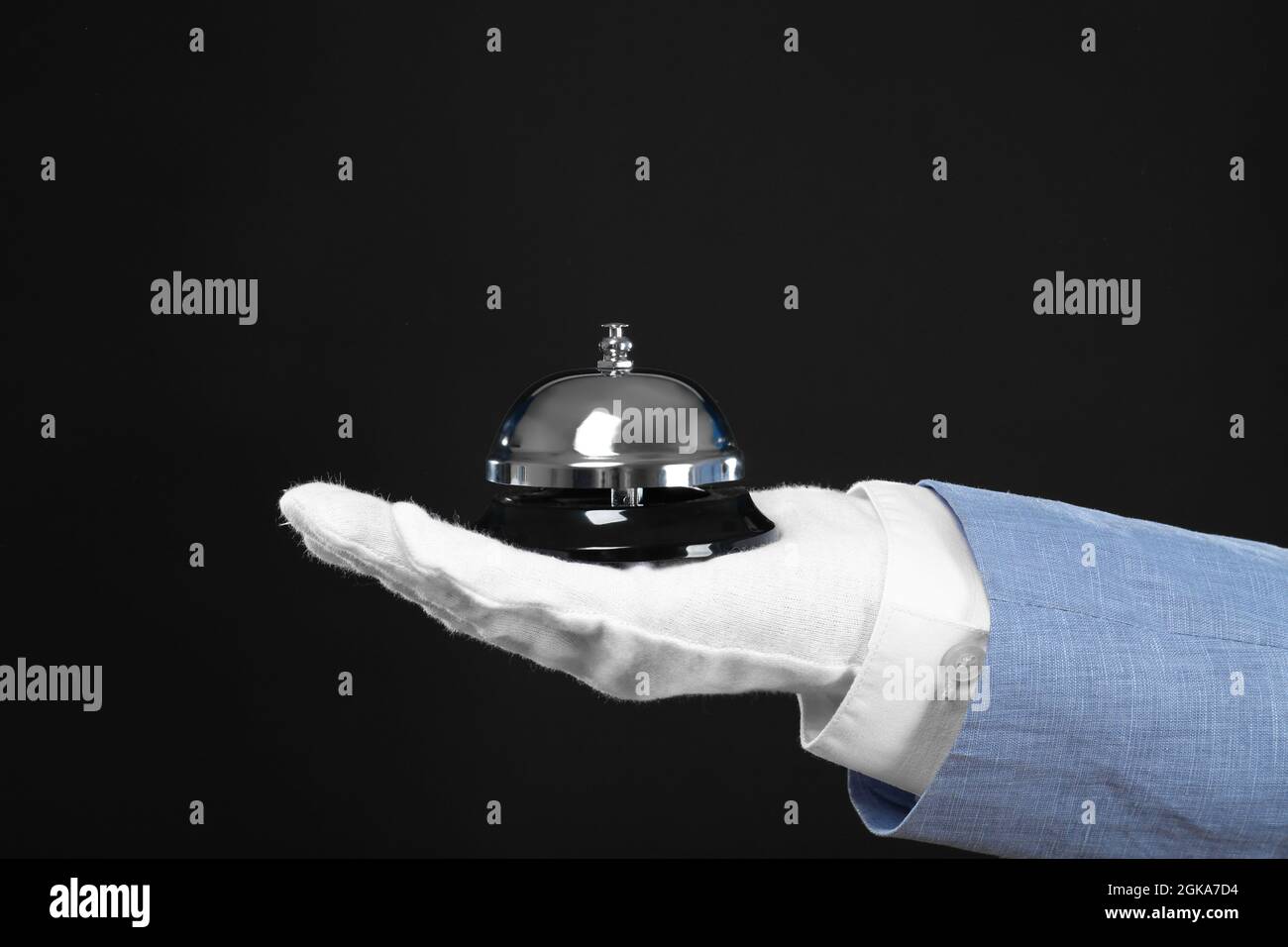 Man holding bell on black background Stock Photo - Alamy