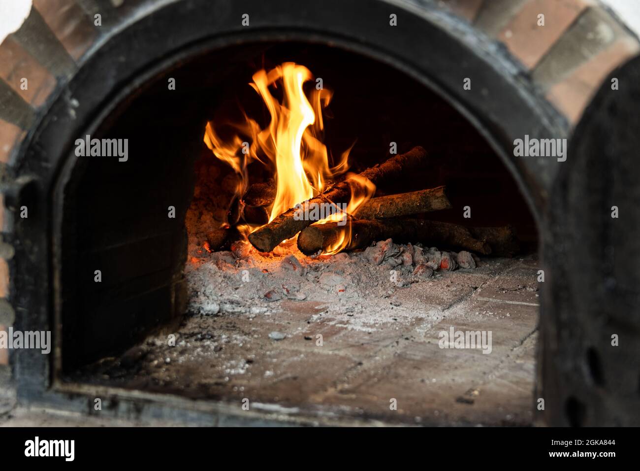 Artisan wood oven built on the outside with the door open and fire ...