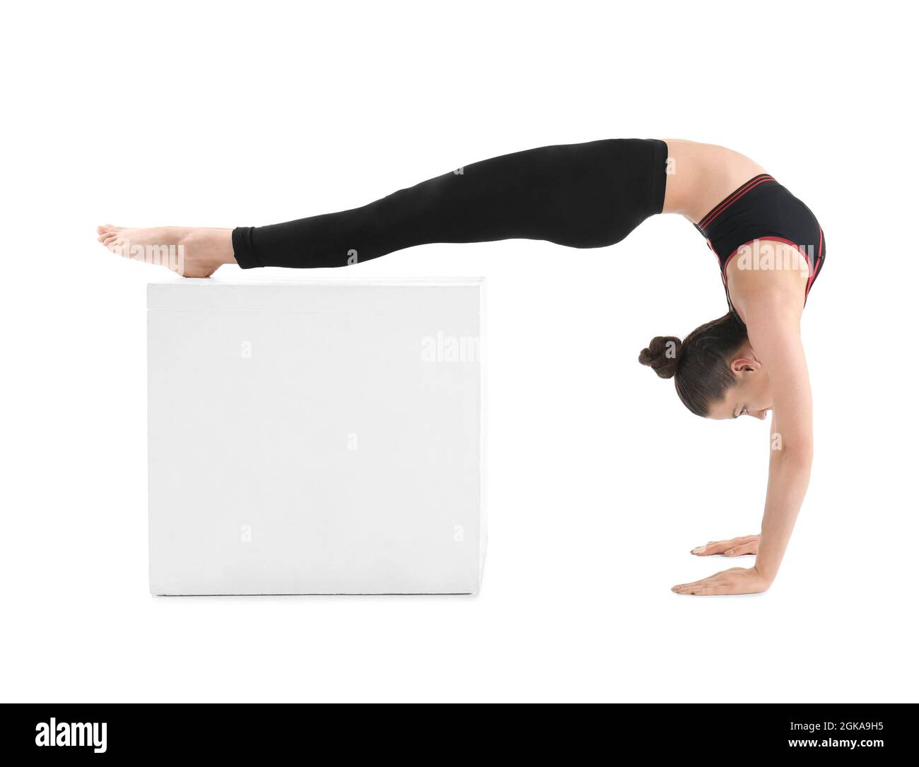 Young beautiful woman doing yoga pose with cube on white background ...