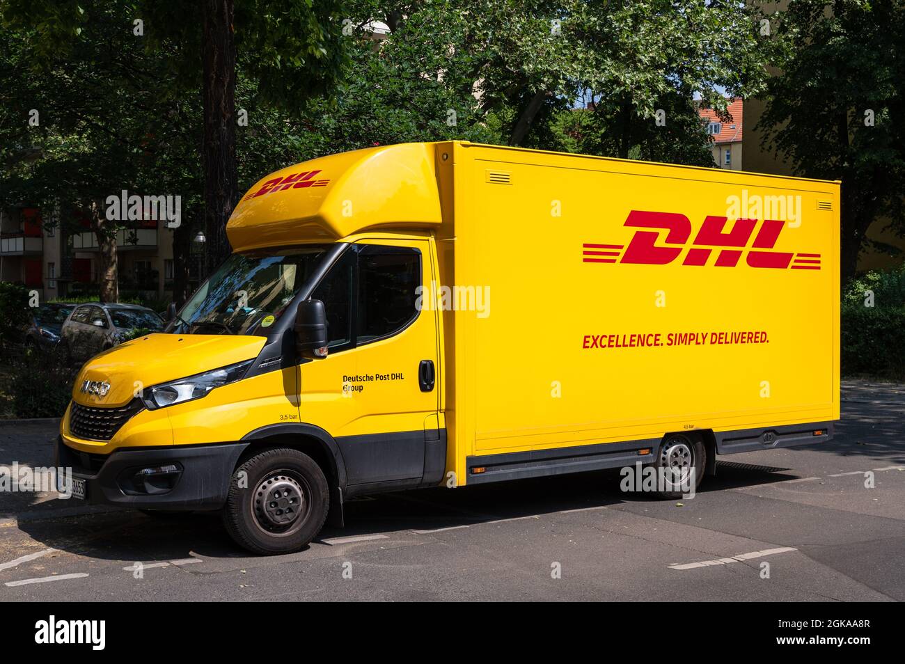Side view from the front right of a DHL van standing on the roadside ...