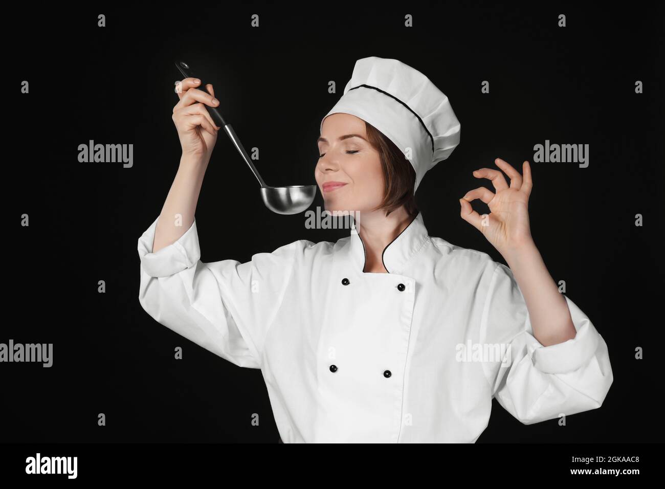 Female chef with ladle on dark background Stock Photo - Alamy
