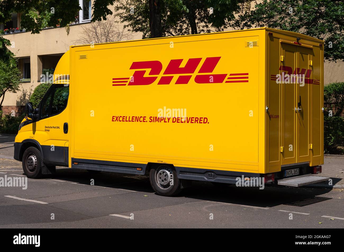 Side view from the rear left of a DHL van standing on the roadside ...