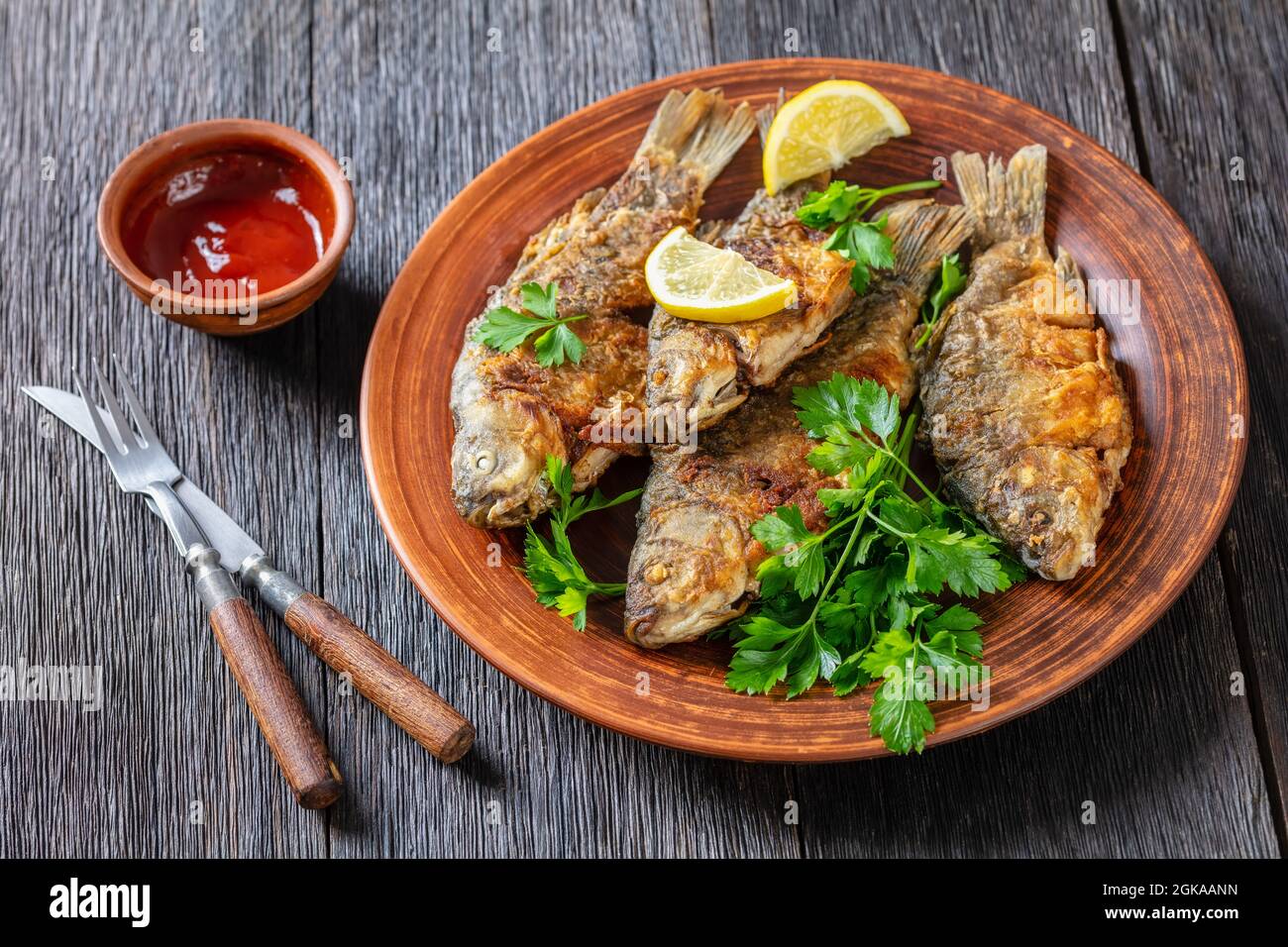 fried crucian carps with golden crispy crust on a clay rustic plate ...