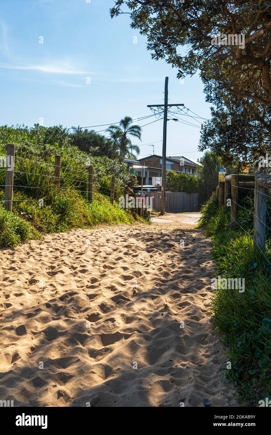 Sandy track to beach with wooden posts and distant houses Stock Photo ...