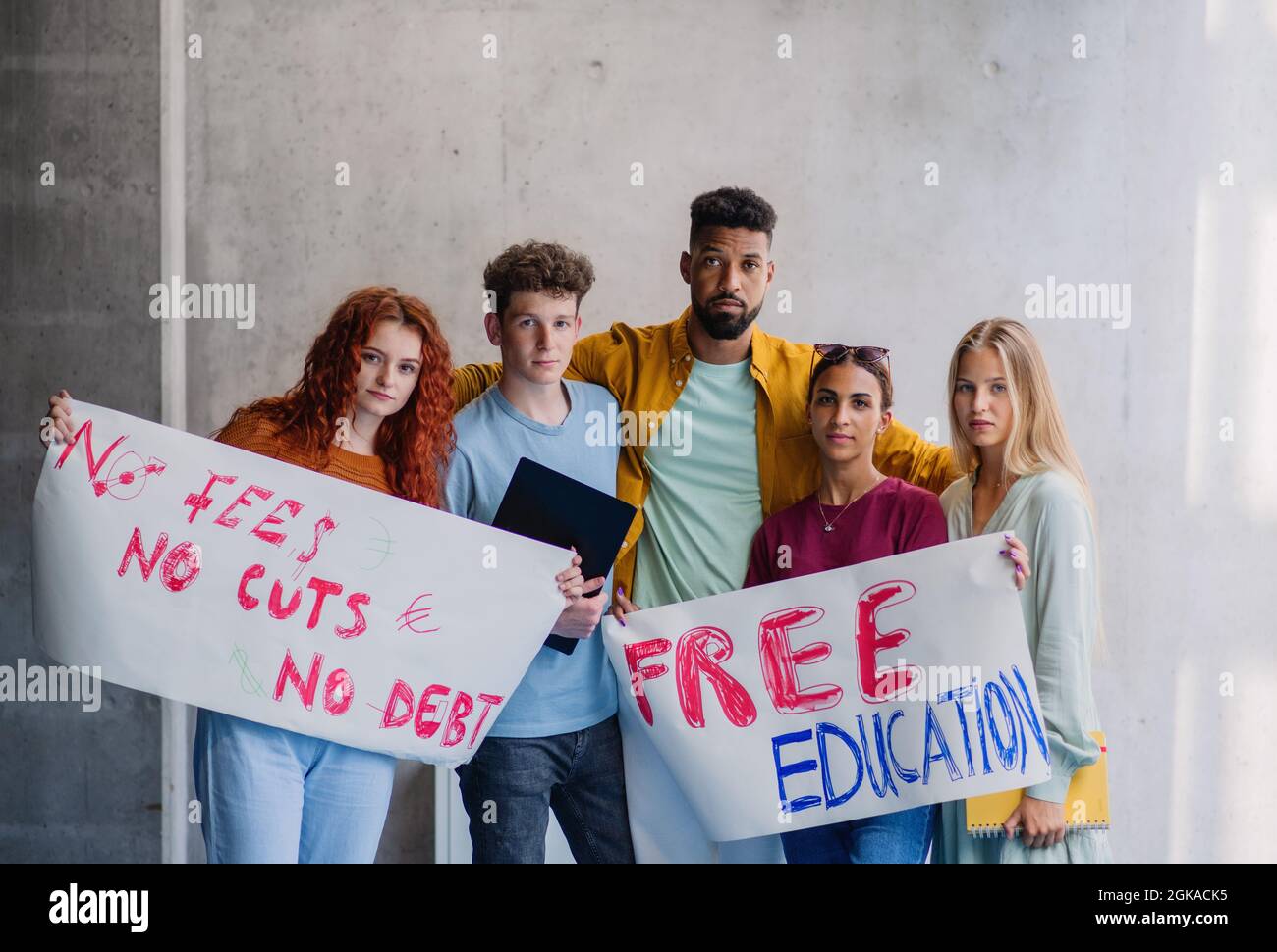 University students activists protesting indoors, looking at camera ...