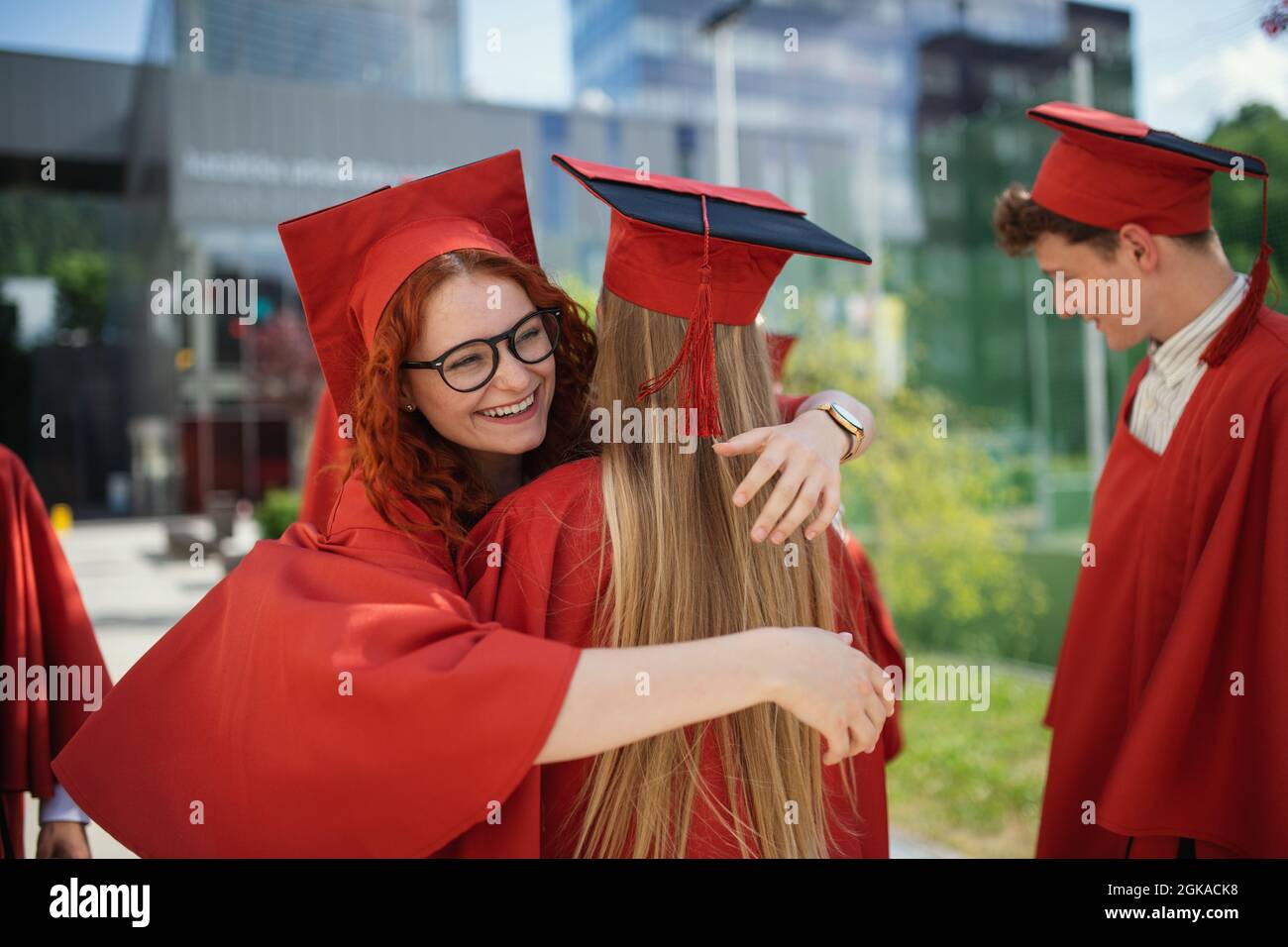 Cheerful university students friends celebrating and hugging outdoors ...