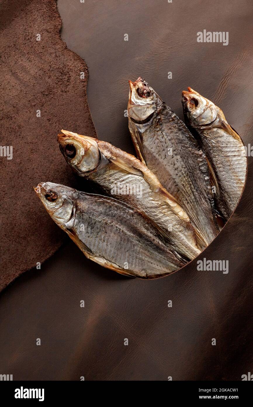 Top view of bunch of salted air-dried roach fish peeking out of hole in ...