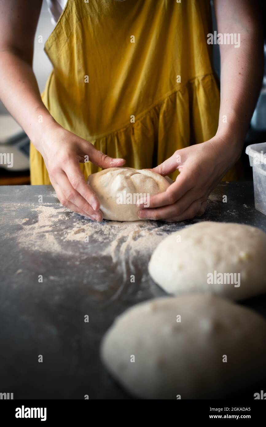 Woman baker forms bread on a steel table in a bakery Stock Photo - Alamy