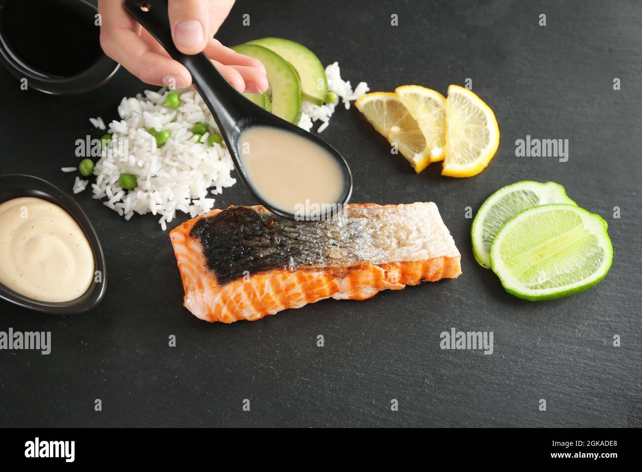 Woman pouring fish sauce on delicious salmon Stock Photo - Alamy