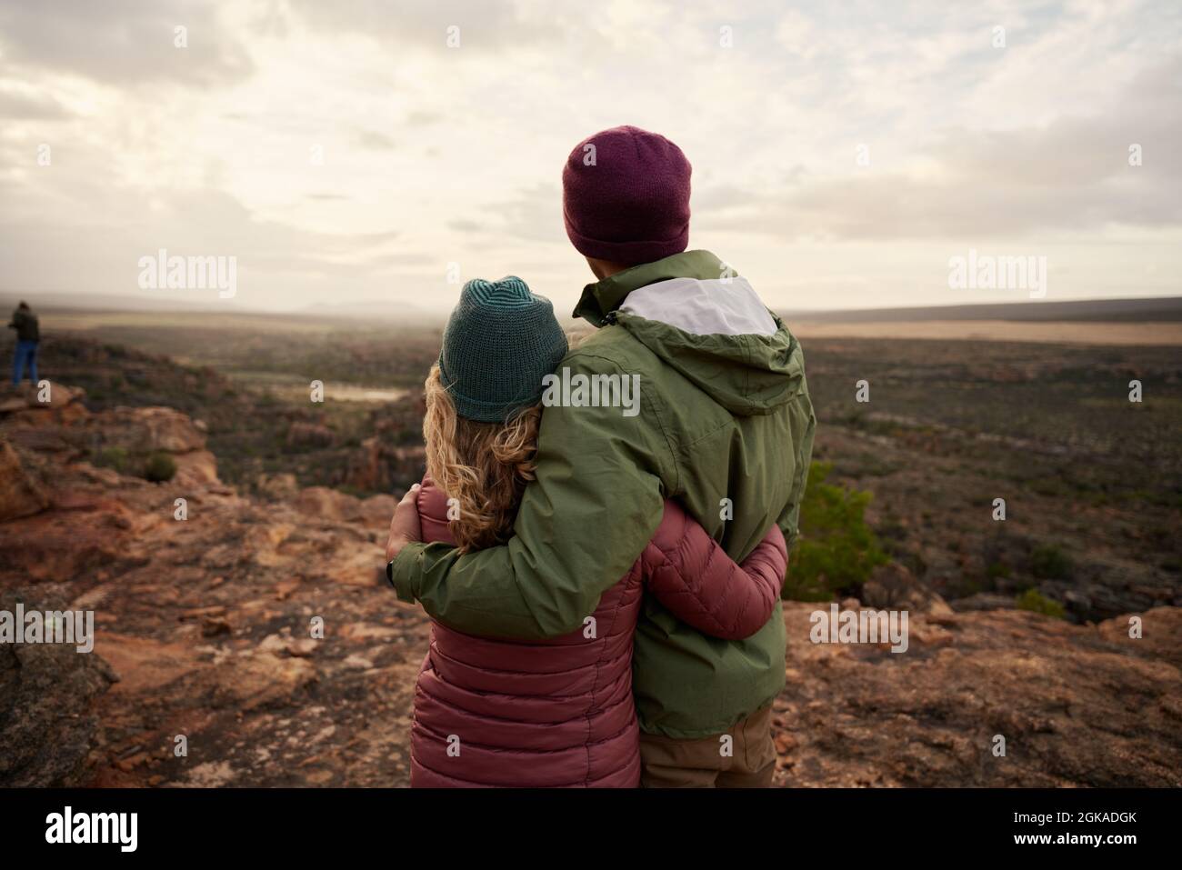 Rear view of young couple in love embracing while looking at beautiful ...