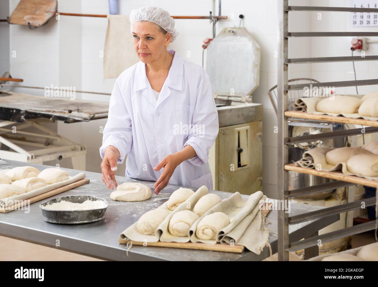 Woman baker forming dough for baking bread Stock Photo - Alamy