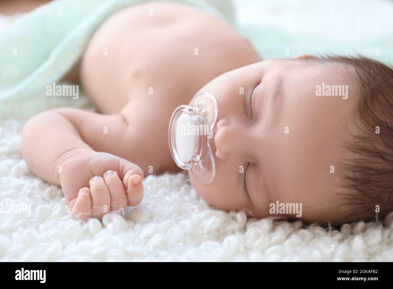 Cute little baby with pacifier sleeping on soft plaid, closeup Stock ...