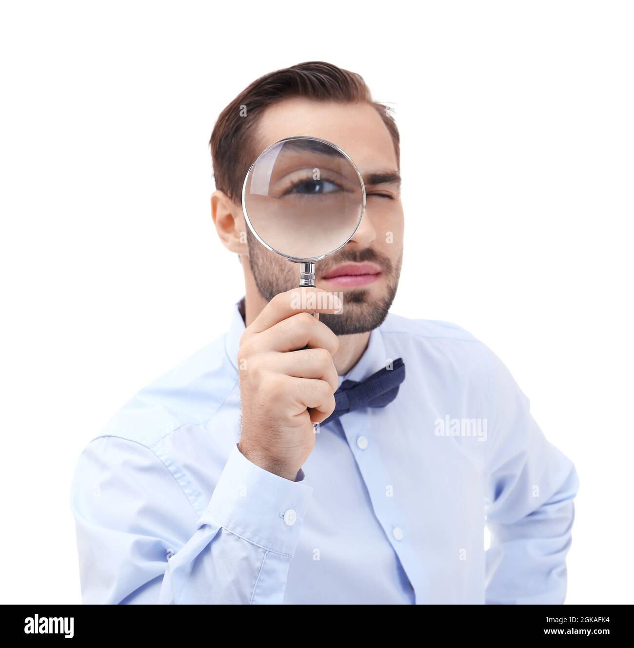 Handsome young man with magnifier on white background Stock Photo - Alamy