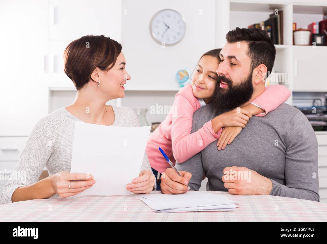 Parents signing property papers Stock Photo - Alamy