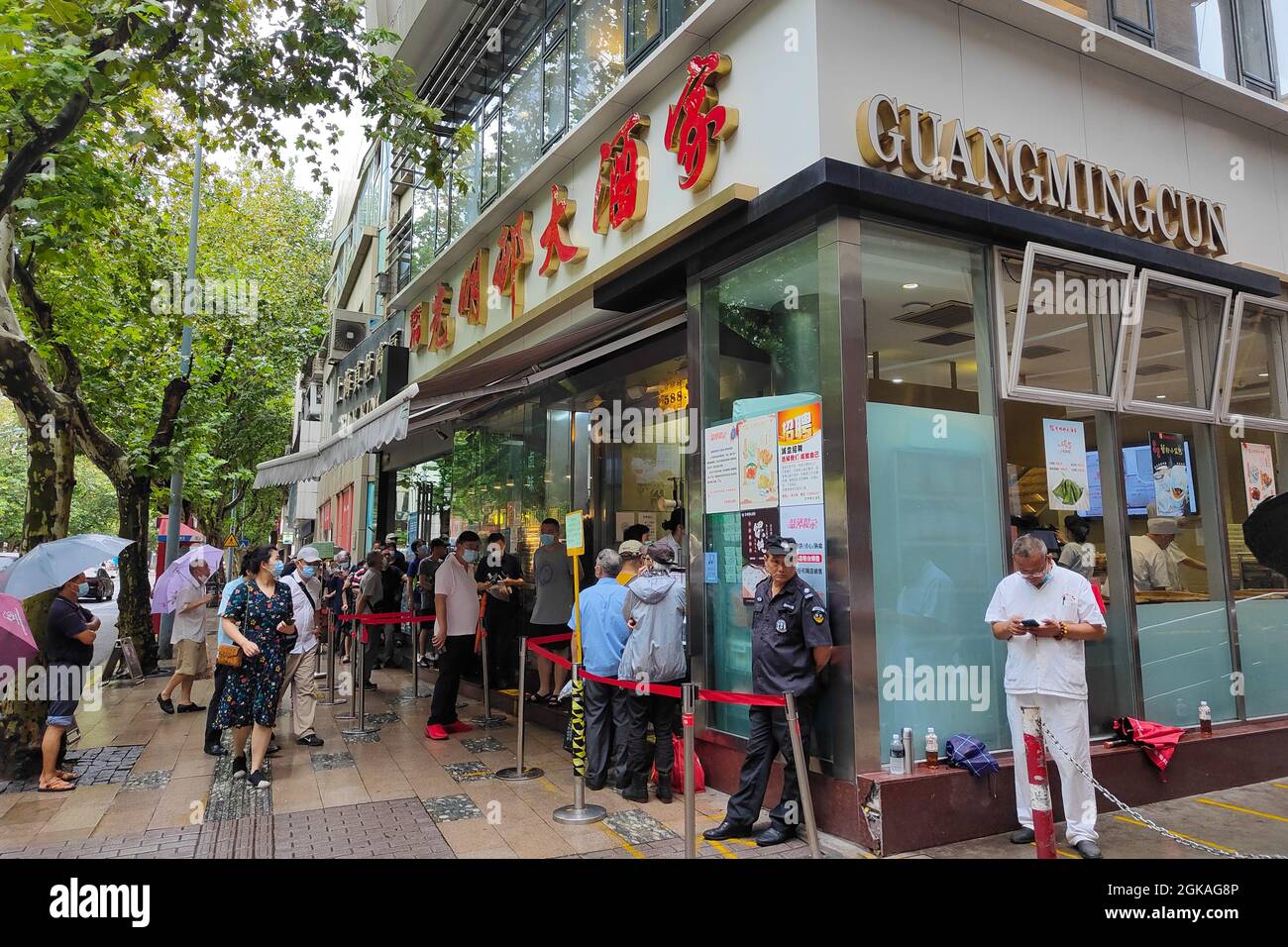 SHANGHAI, CHINA - SEPTEMBER 14, 2021 - People queue in the rain to buy ...