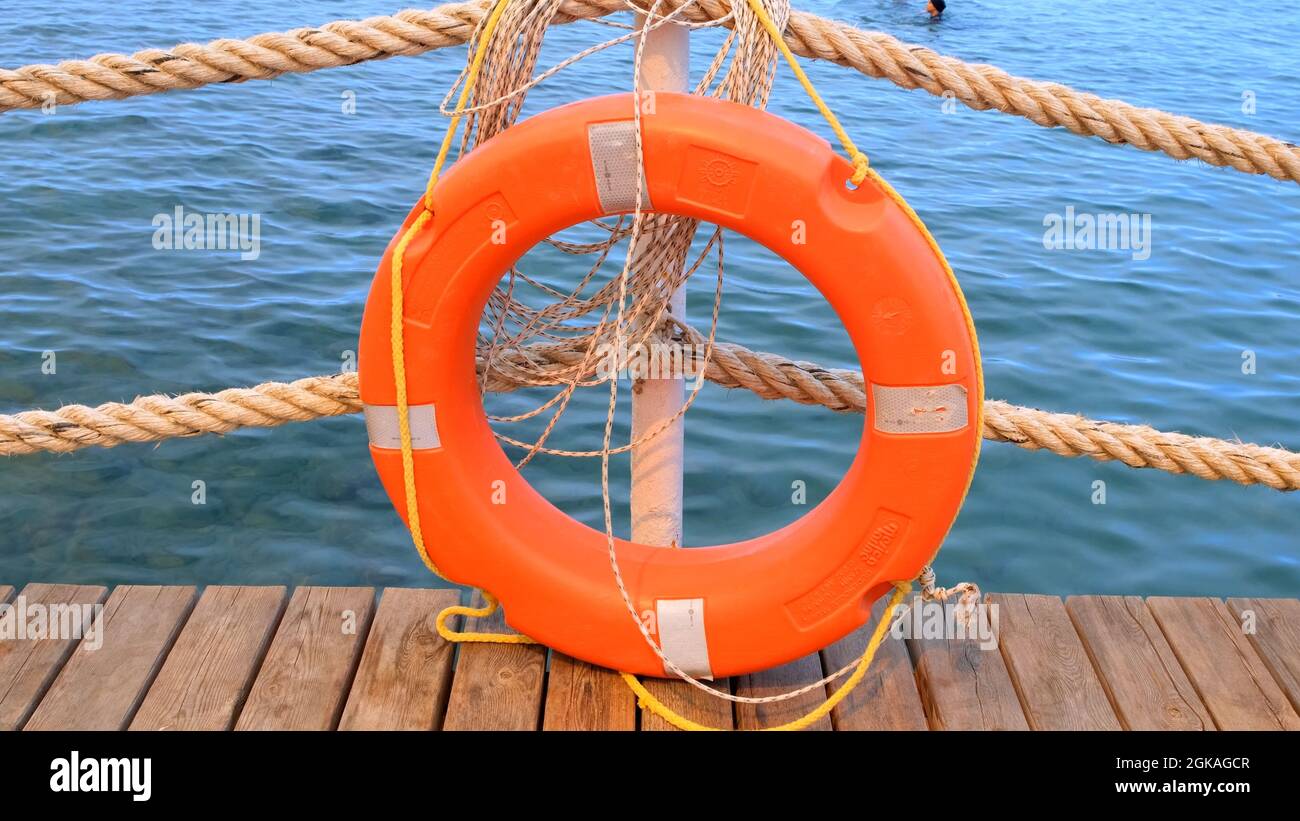 Orange lifeline and sea ropes on the background of the sea and blue sky ...