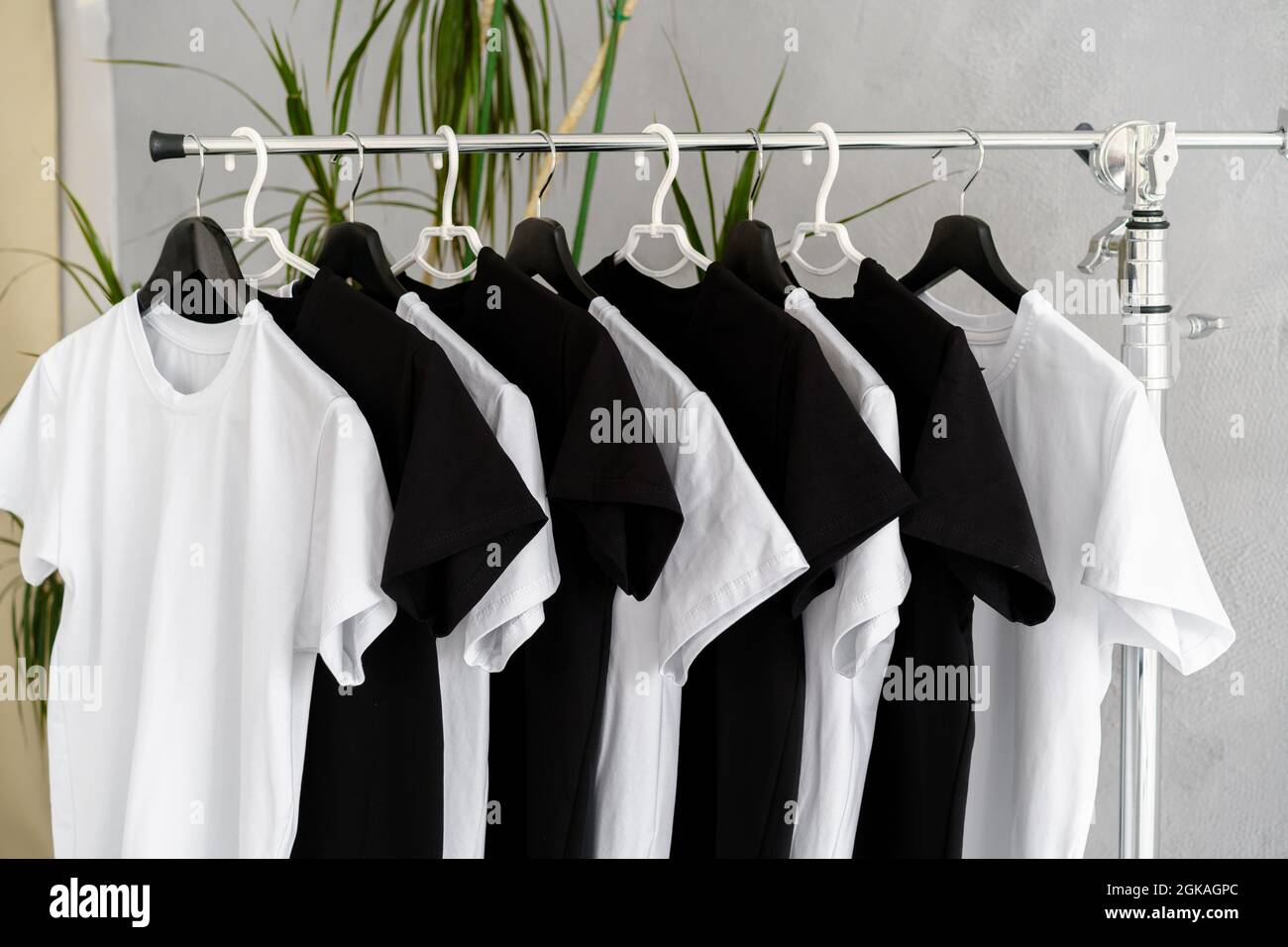 Row of black and white t-shirts hanging on rack Stock Photo - Alamy