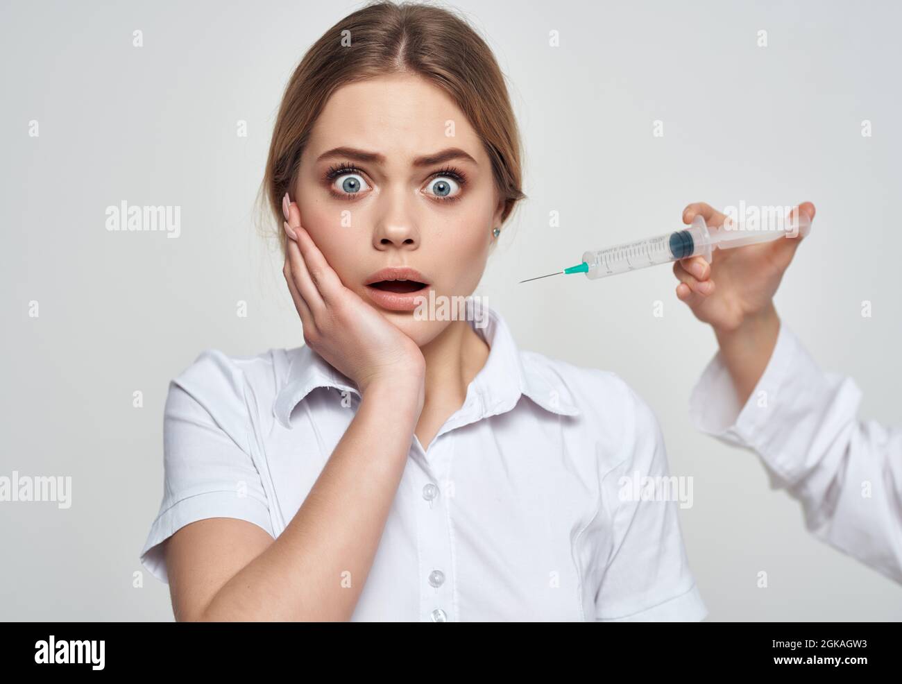 woman patient syringe in the hands of a doctor fear of injections ...