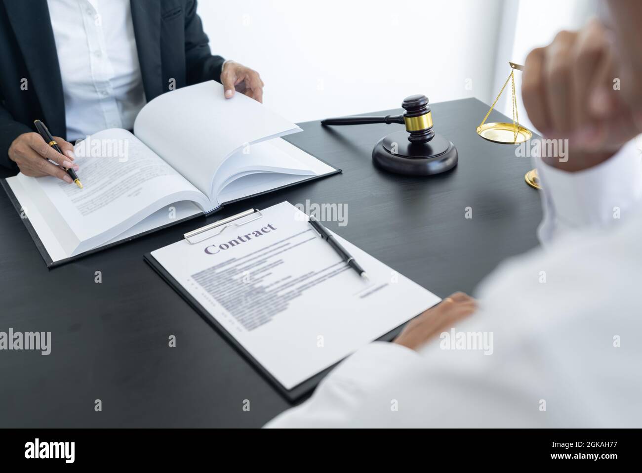 law,libra scale and hammer on the table, 2 lawyers are discussing about ...