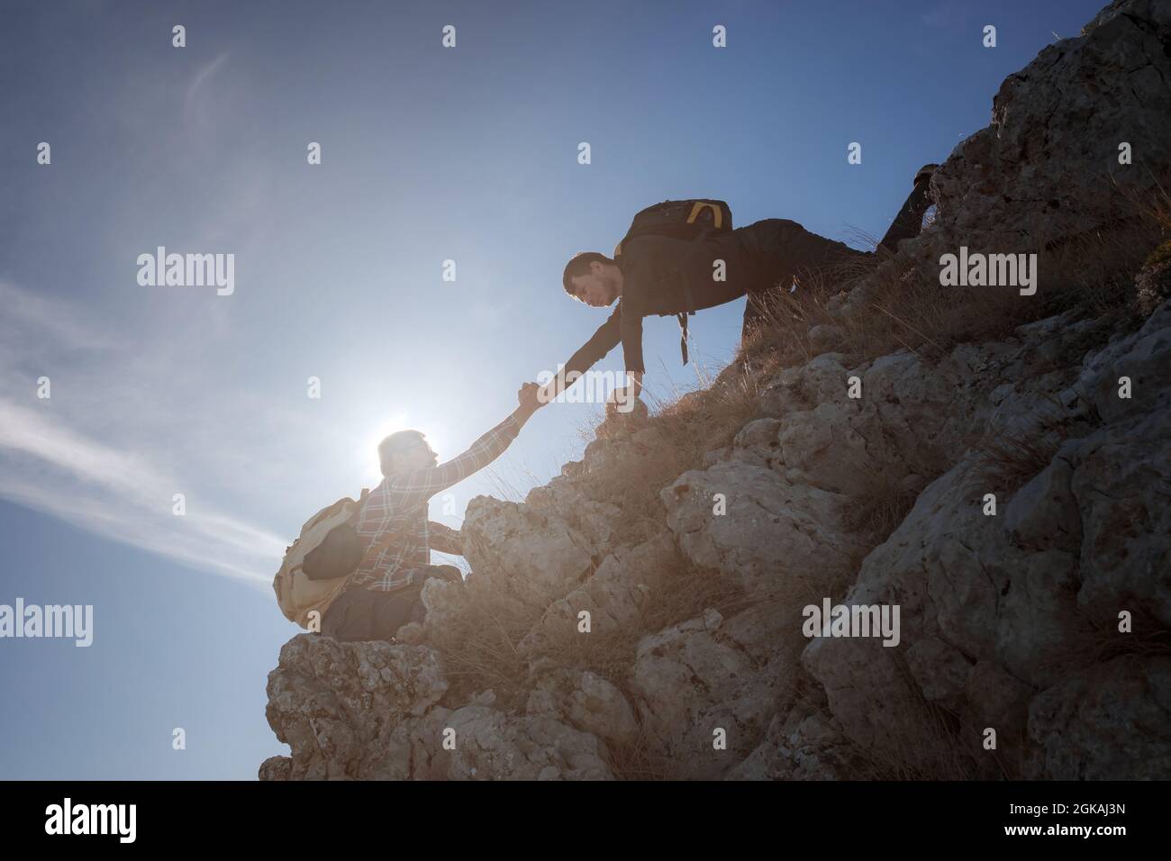 Help and assistance concept. Silhouettes of two people climbing ...