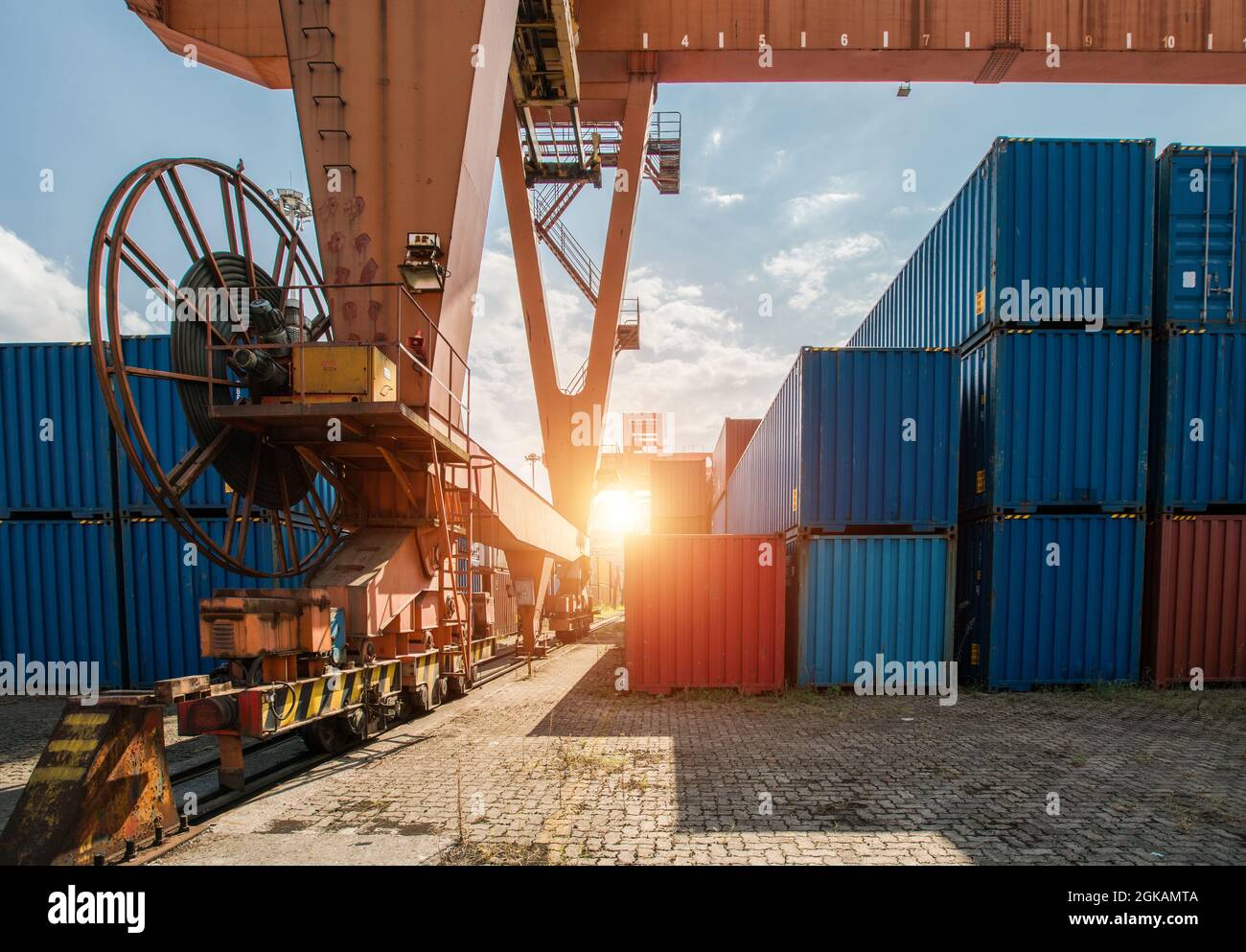 Sun shining over a container yard and crane at a port Stock Photo - Alamy