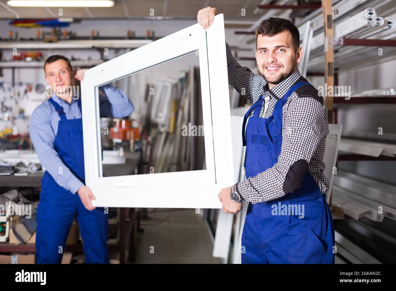 calm male professional labours with finished PVC profiles and windows ...