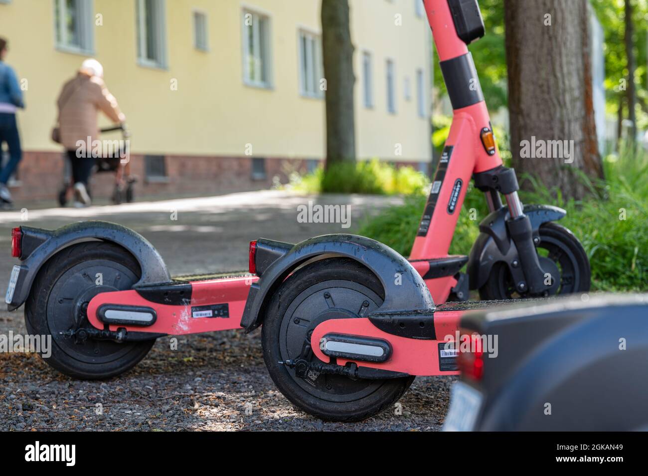Partial view of three rental electric rollers parked on the sidewalk ...