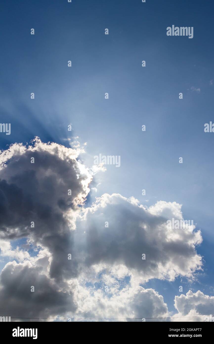 Sun peeking through the clouds background Stock Photo - Alamy